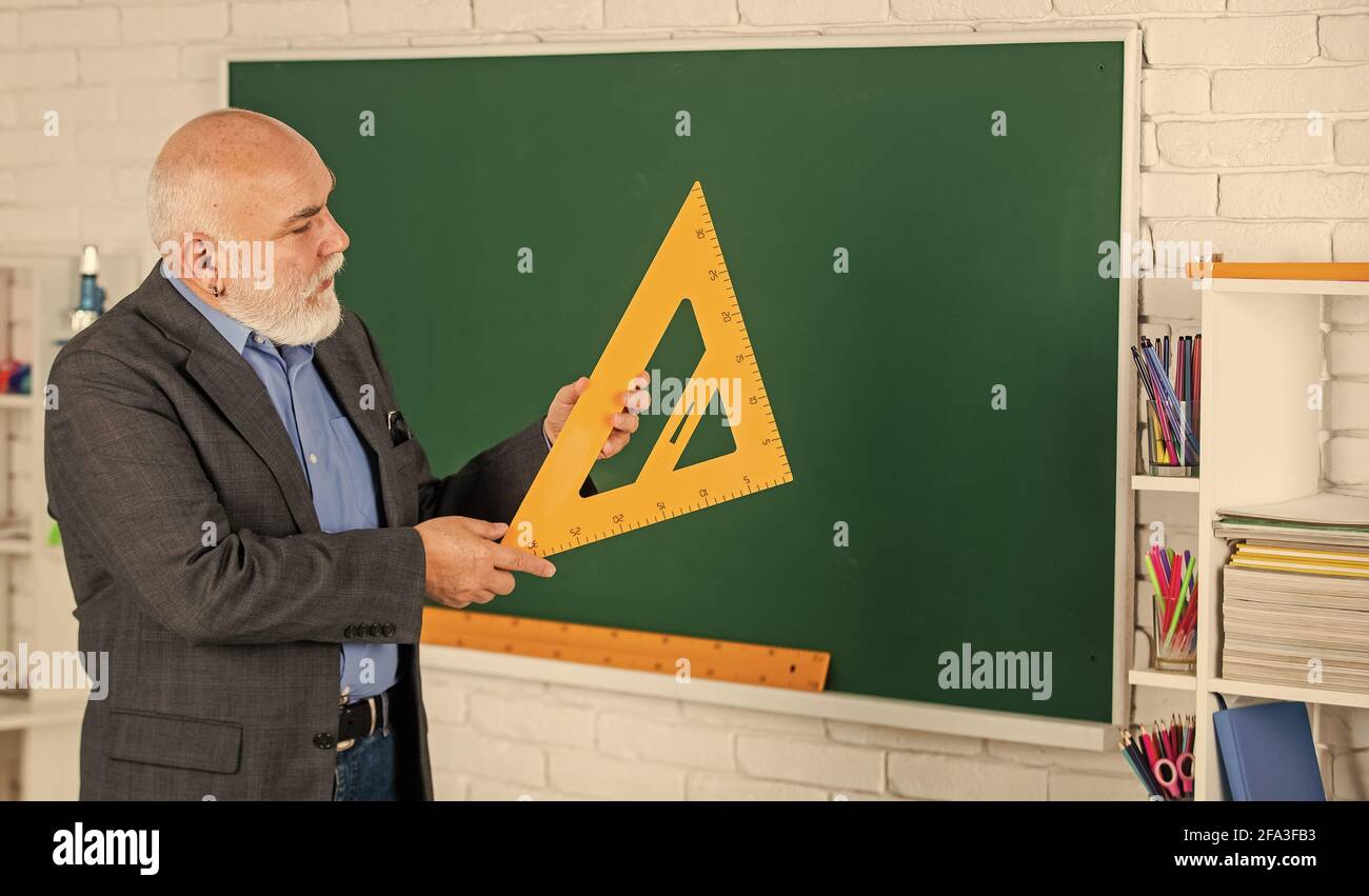 Maths Problem Solving. senior man teacher use math triangle tool ...