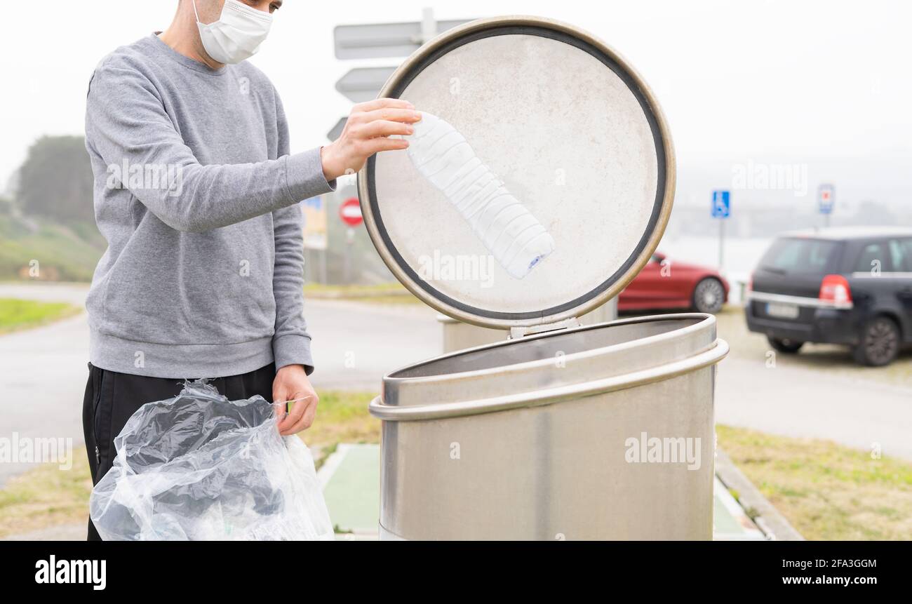 Man throwing plastic containers at plastic recycling point. Social ...