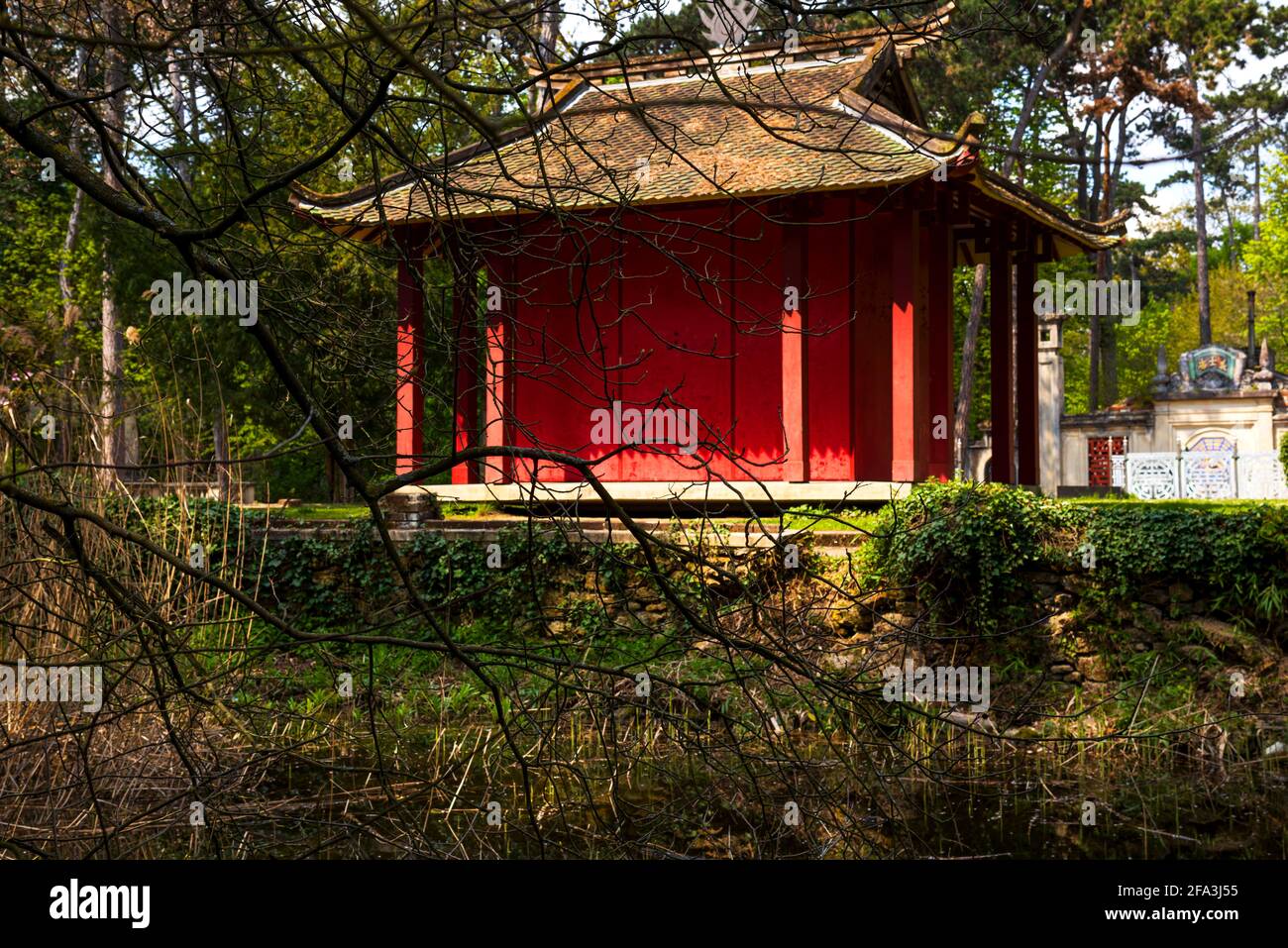 Indochinese temple of remembrance. Red temple over the pond in Tropical ...