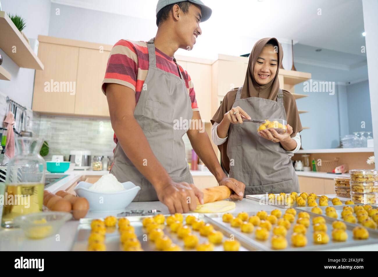 muslim couple making nastar snack cake together in the kitchen during ...