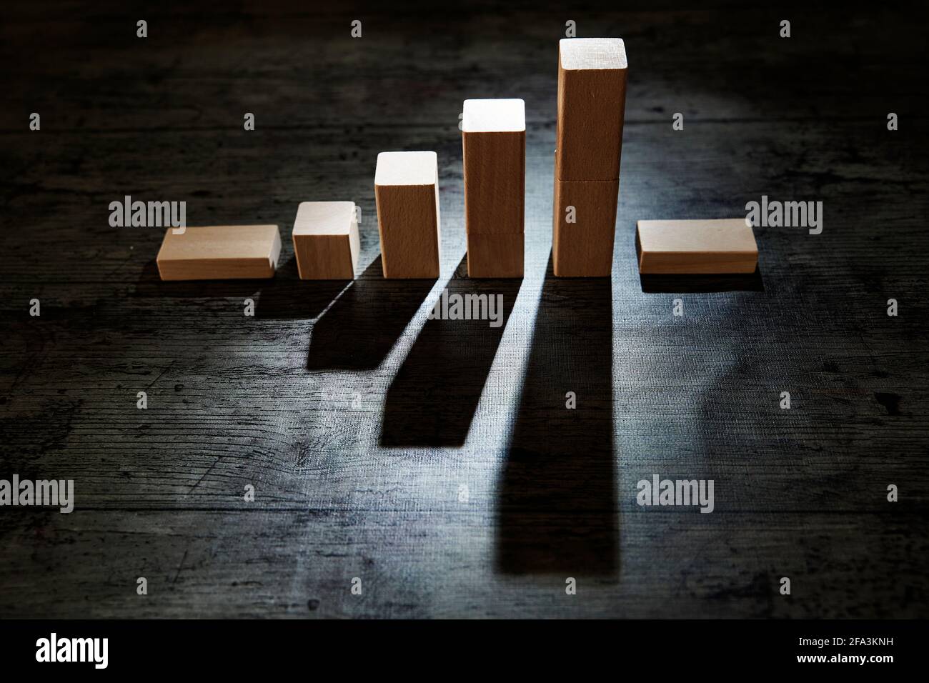 Wooden toy blocks set in graph form growing with green block showing ...