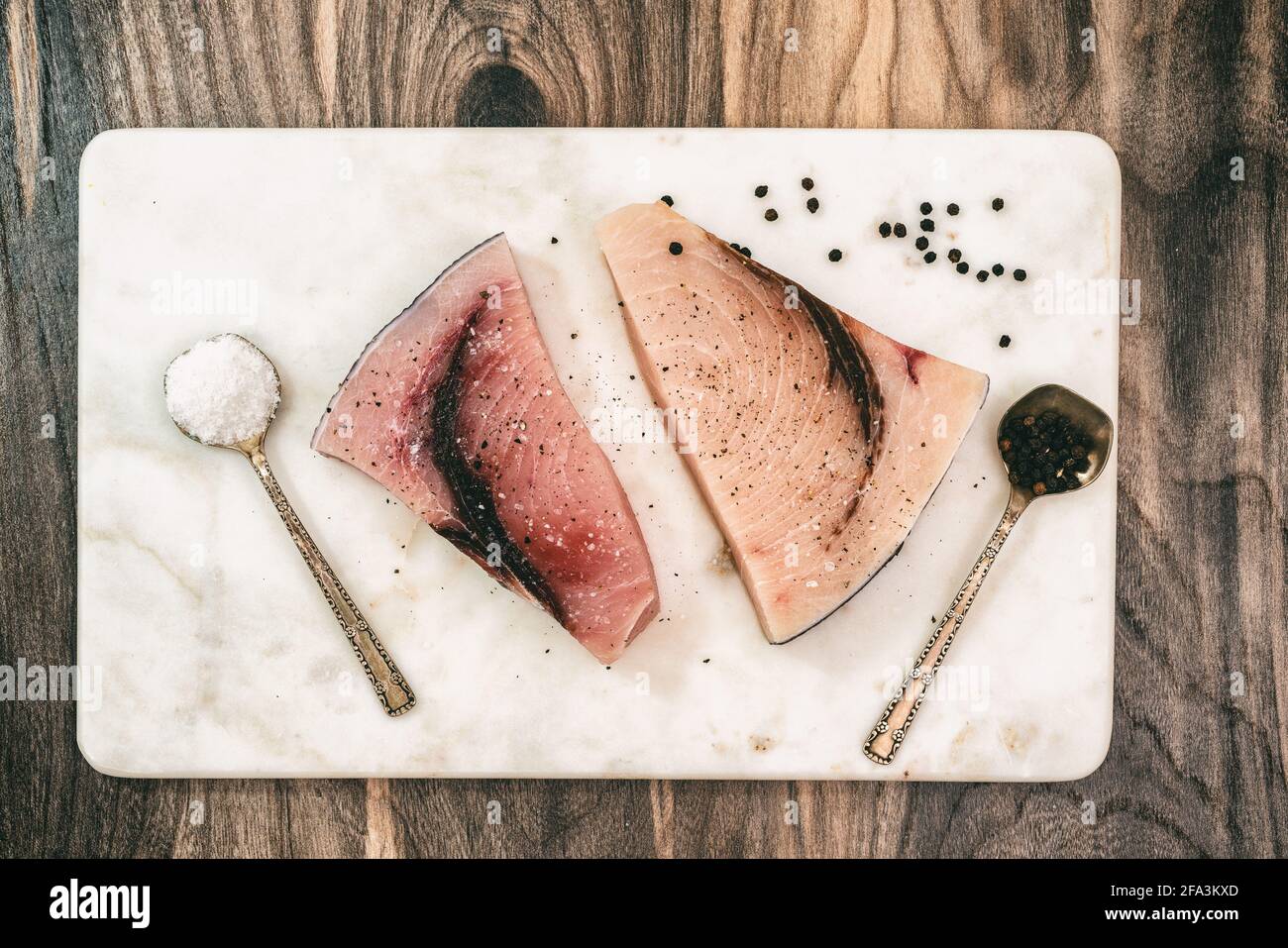 Raw swordfish. Two pieces of fresh raw fish steaks with salt and black ...