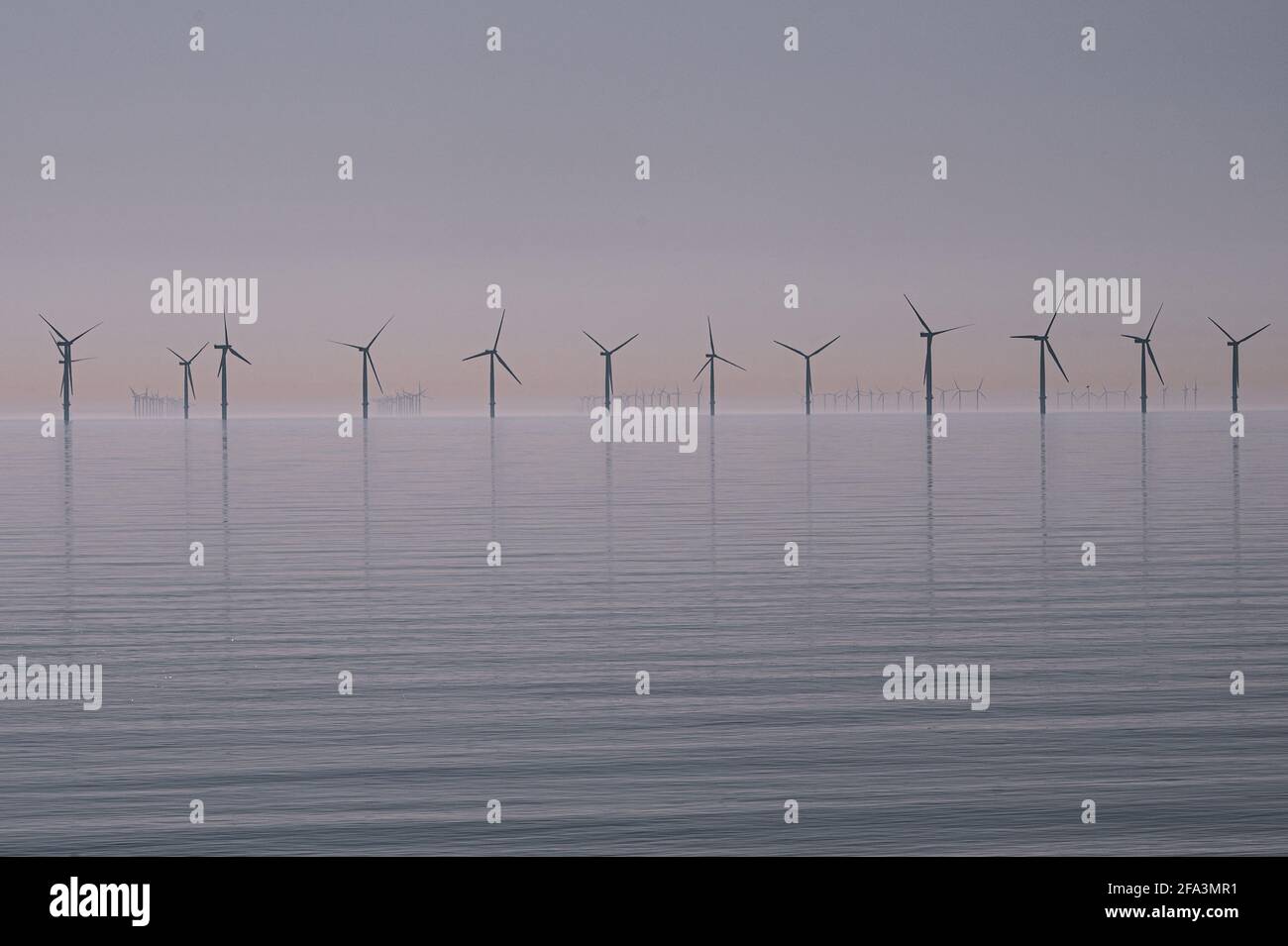Early morning wind farm turbines off Clacton on Sea beach, Essex, UK ...