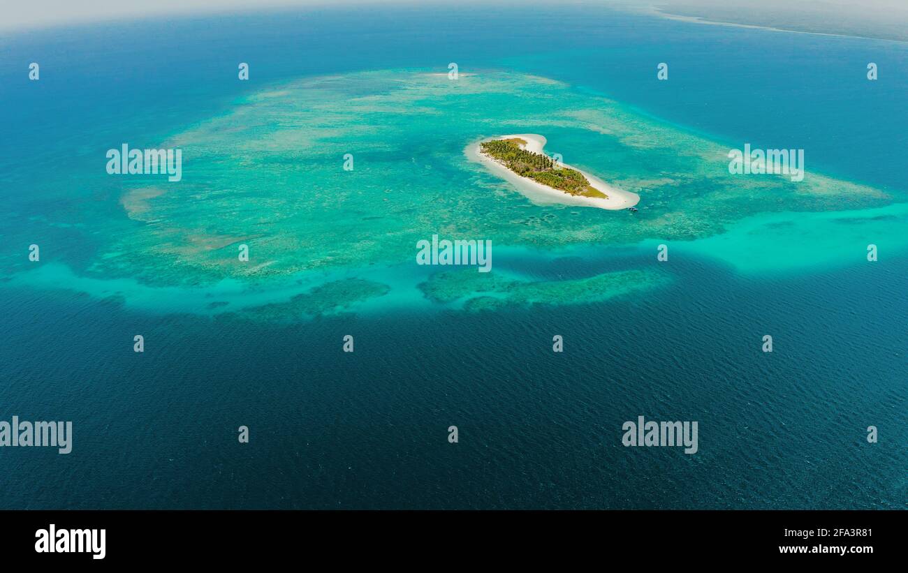 Small tropical island in the blue sea with a coral reef and the beach ...