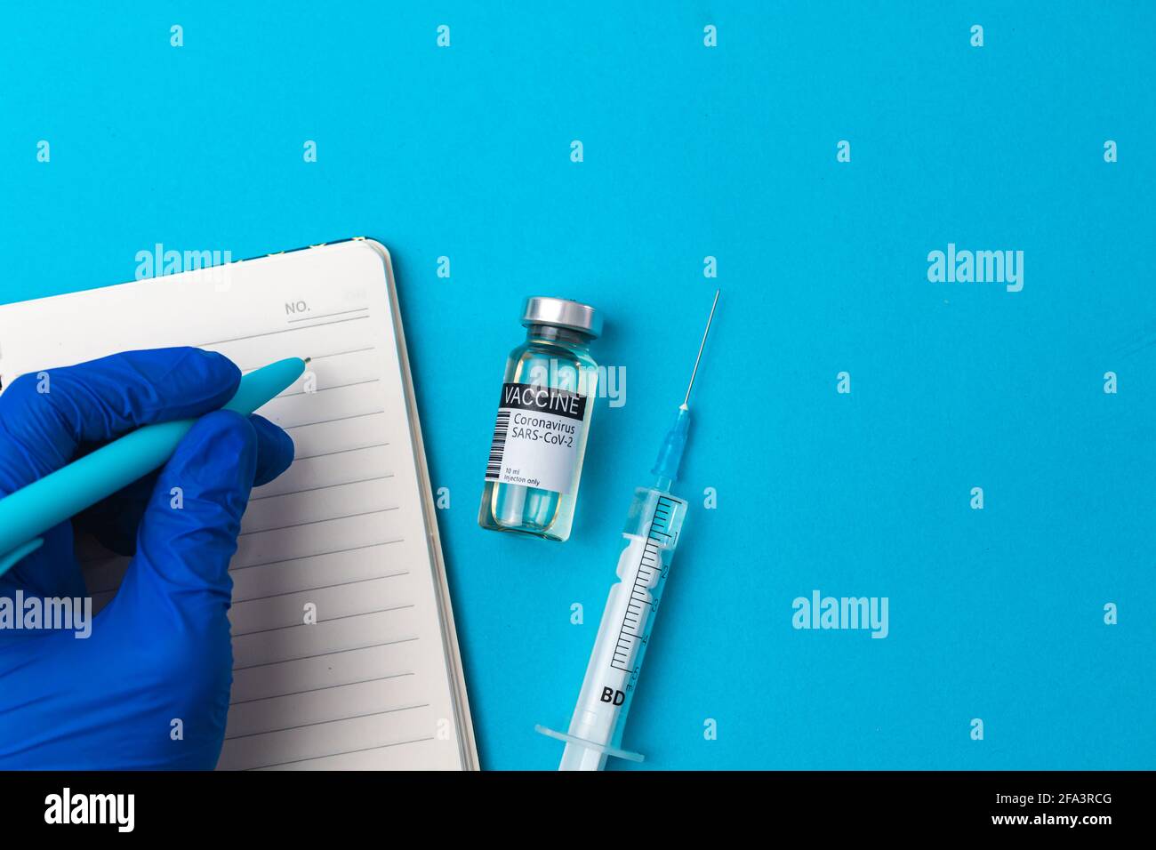 Vaccination background with doctor hand, vaccine vials and syringe on a ...