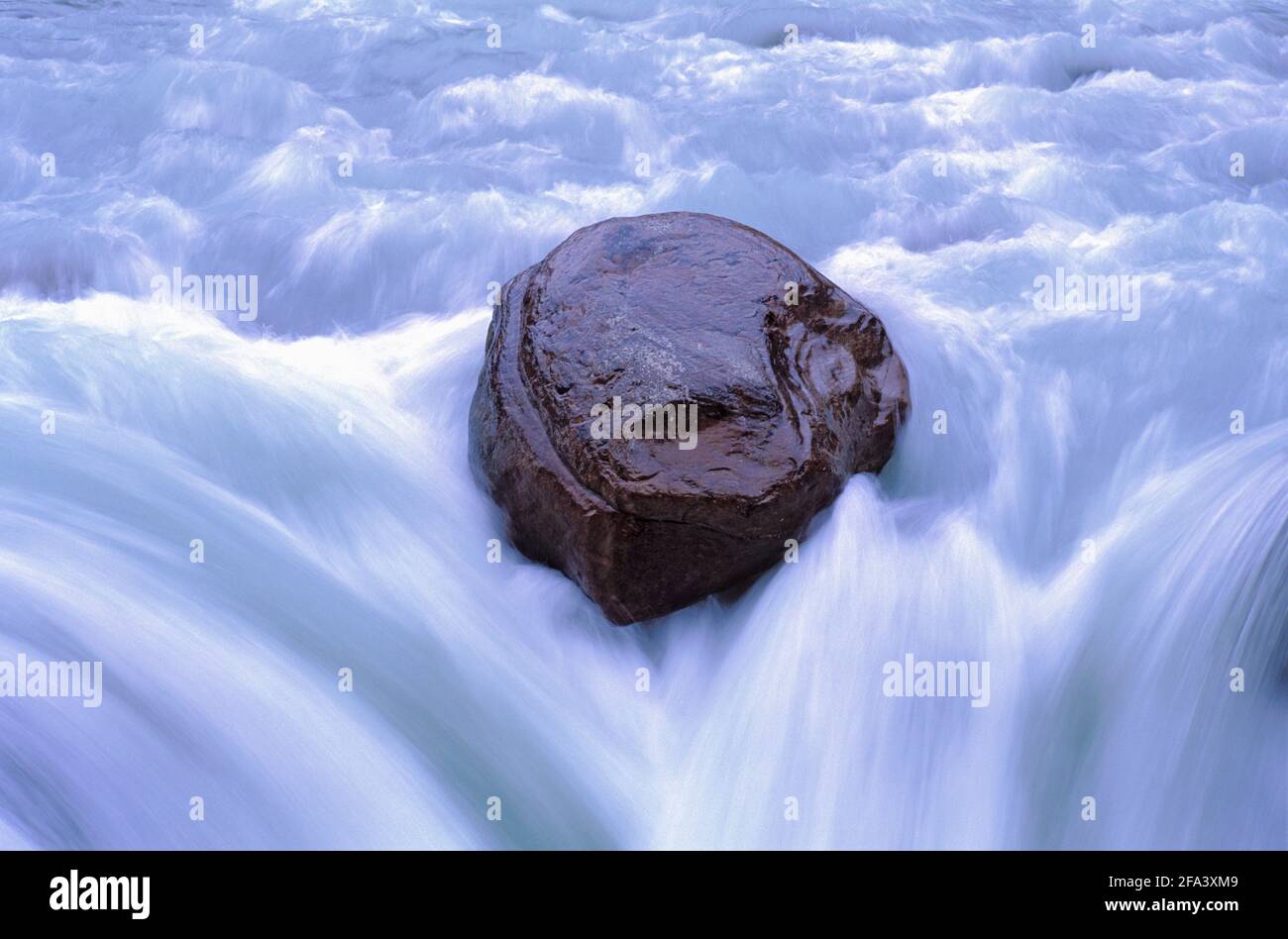 Single Rock in River Stream. Long exposure of water flowing, a concept ...