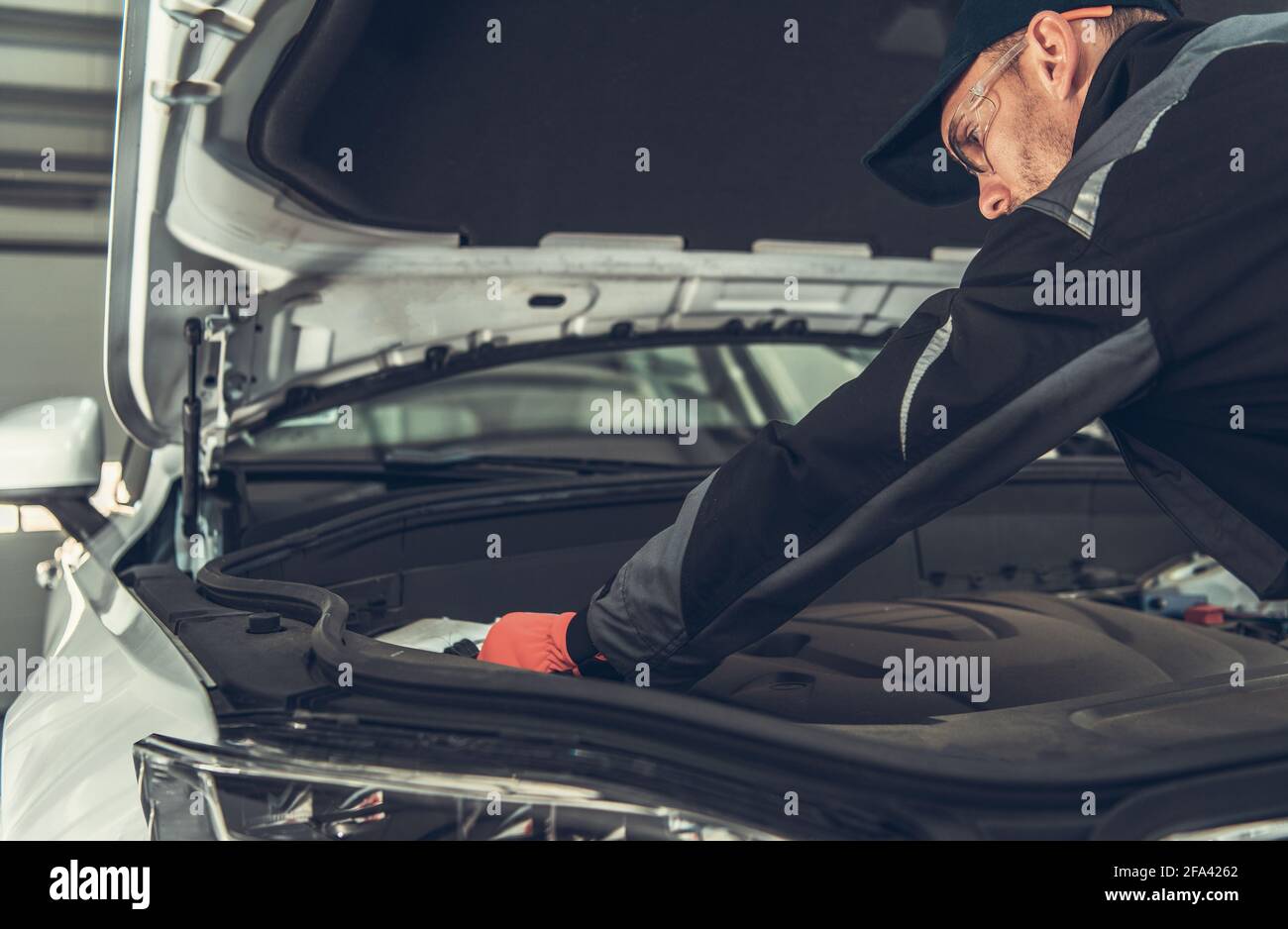 Caucasian Automotive Industry Car Mechanic Checking Engine Compartment ...
