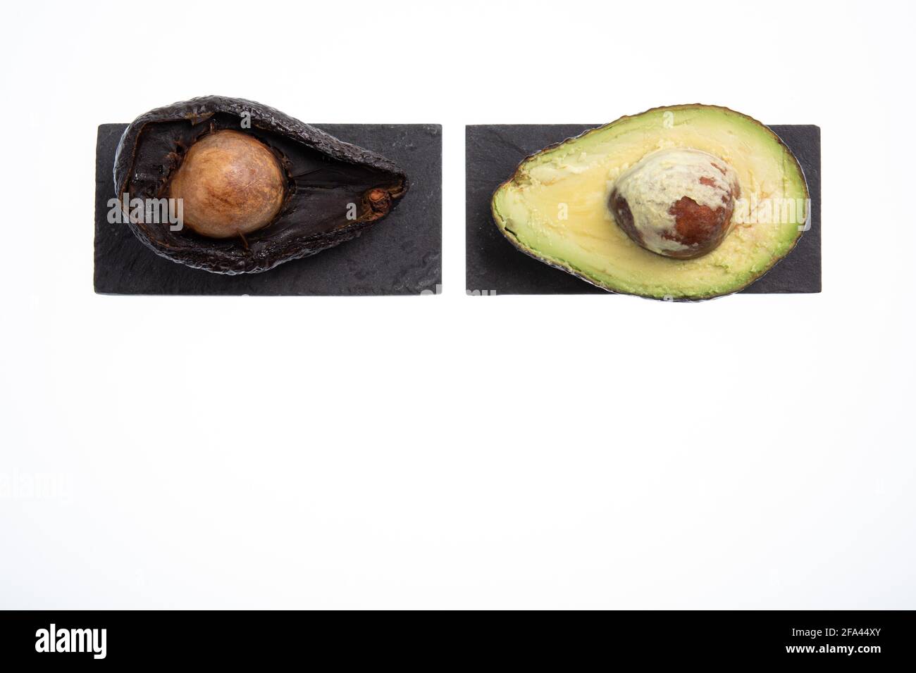 Fresh and ripe avocado next to rotting avocado cut in half with seed ...