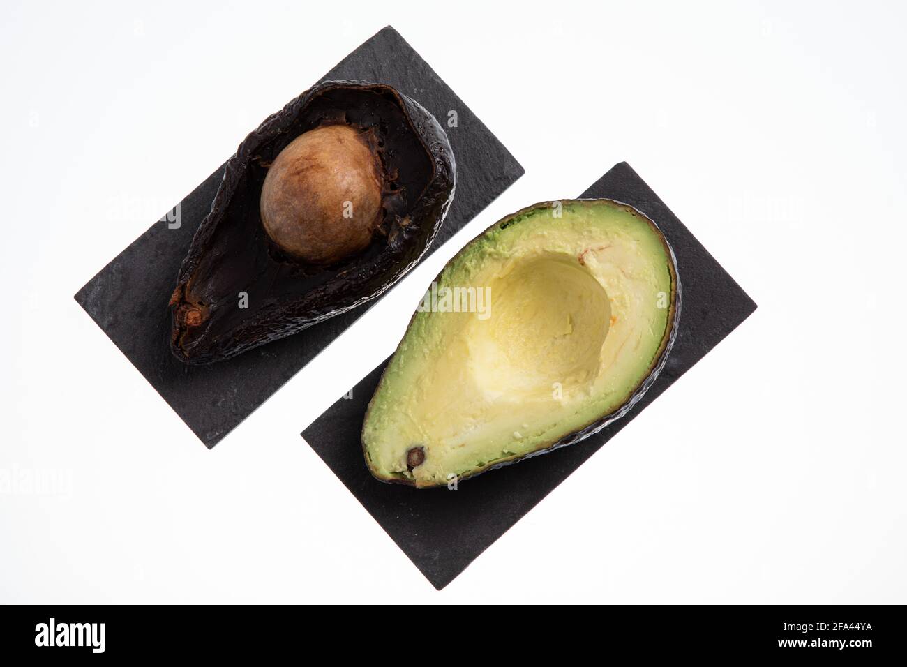 Fresh and ripe avocado next to rotting avocado cut in half with seed ...