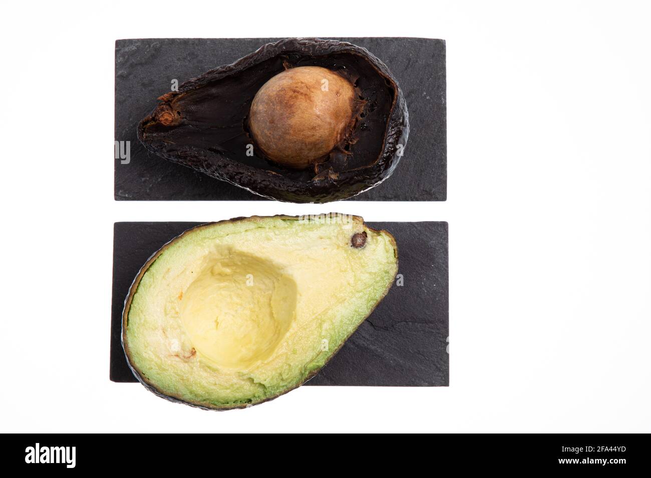 Fresh and ripe avocado next to rotting avocado cut in half with seed ...