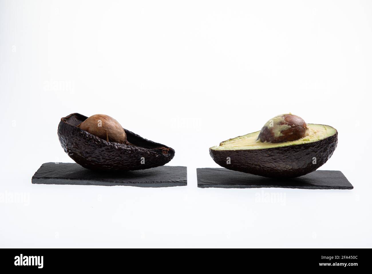 Fresh and ripe avocado next to rotting avocado cut in half with seed ...