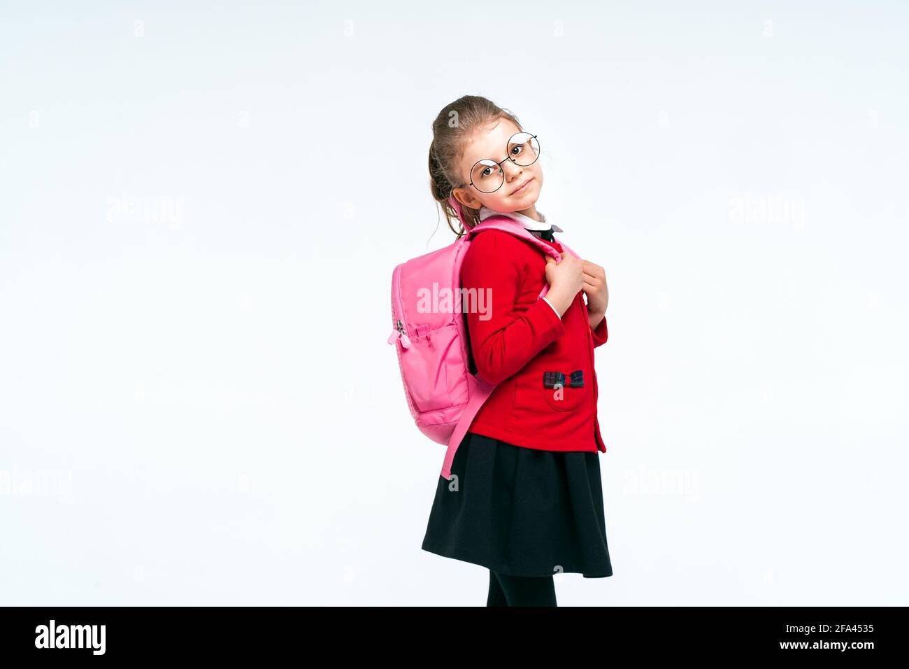 Adorable little girl in red school jacket, black dress, rounded Stock ...