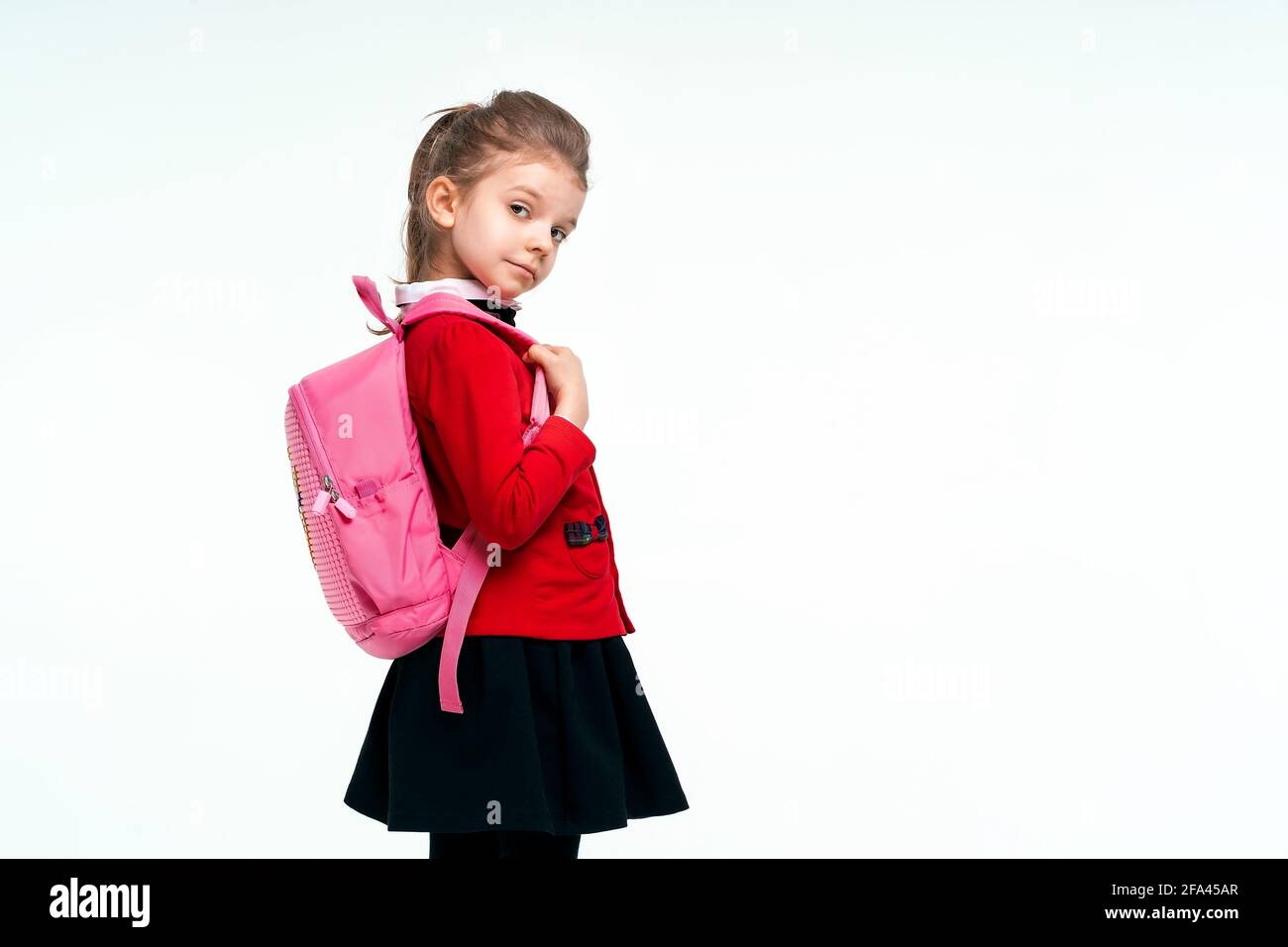 Adorable little girl in red school jacket, black dress, on to th Stock ...