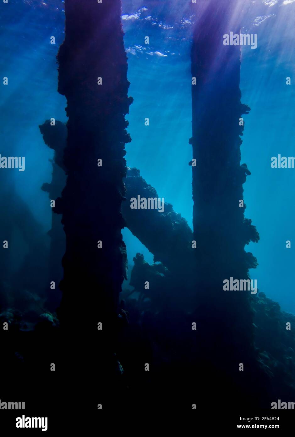 Collapsed pier underwater with sunlight rays piercing through clear ...