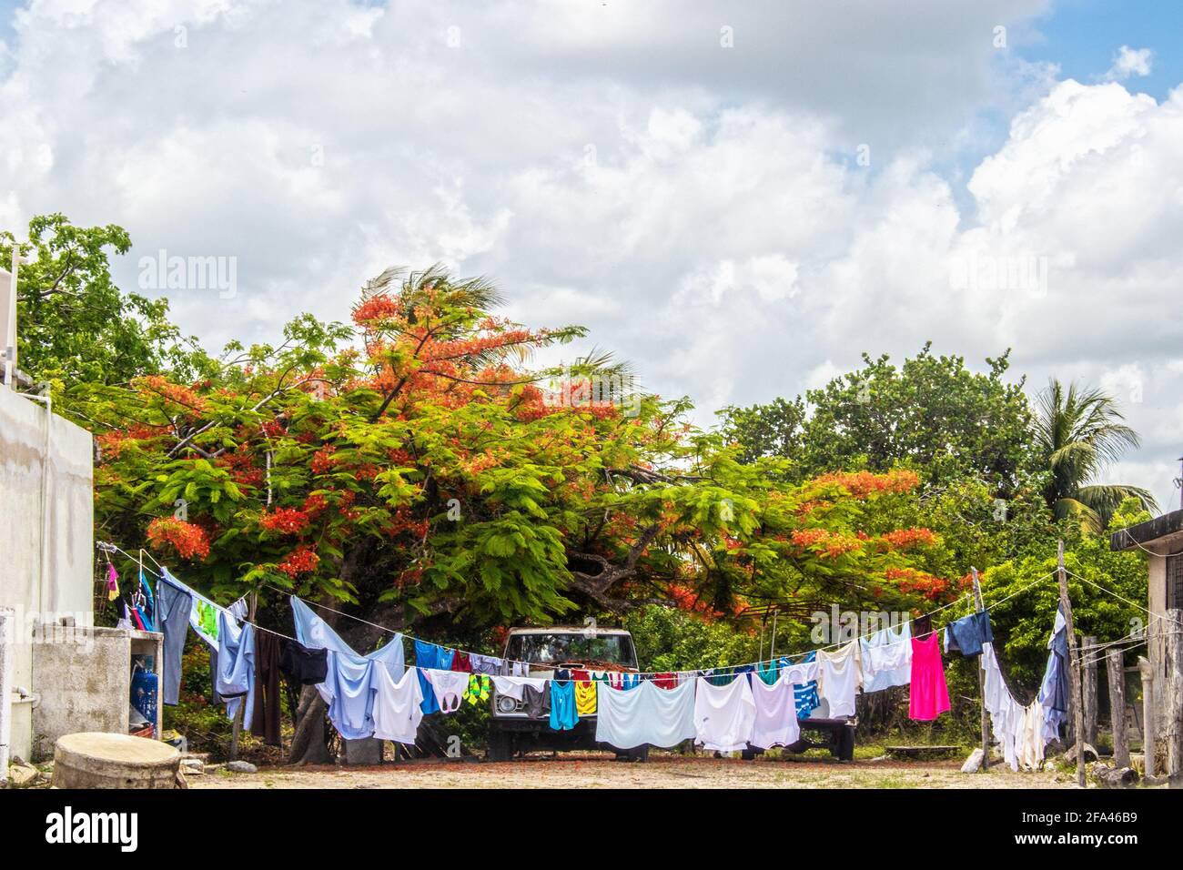 Clothing hanging on line to dry on drooping line by Mexican house with ...