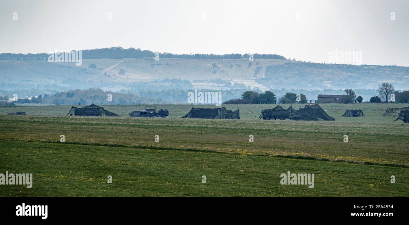 british army on exercise with equipment and machinery under camouflage ...