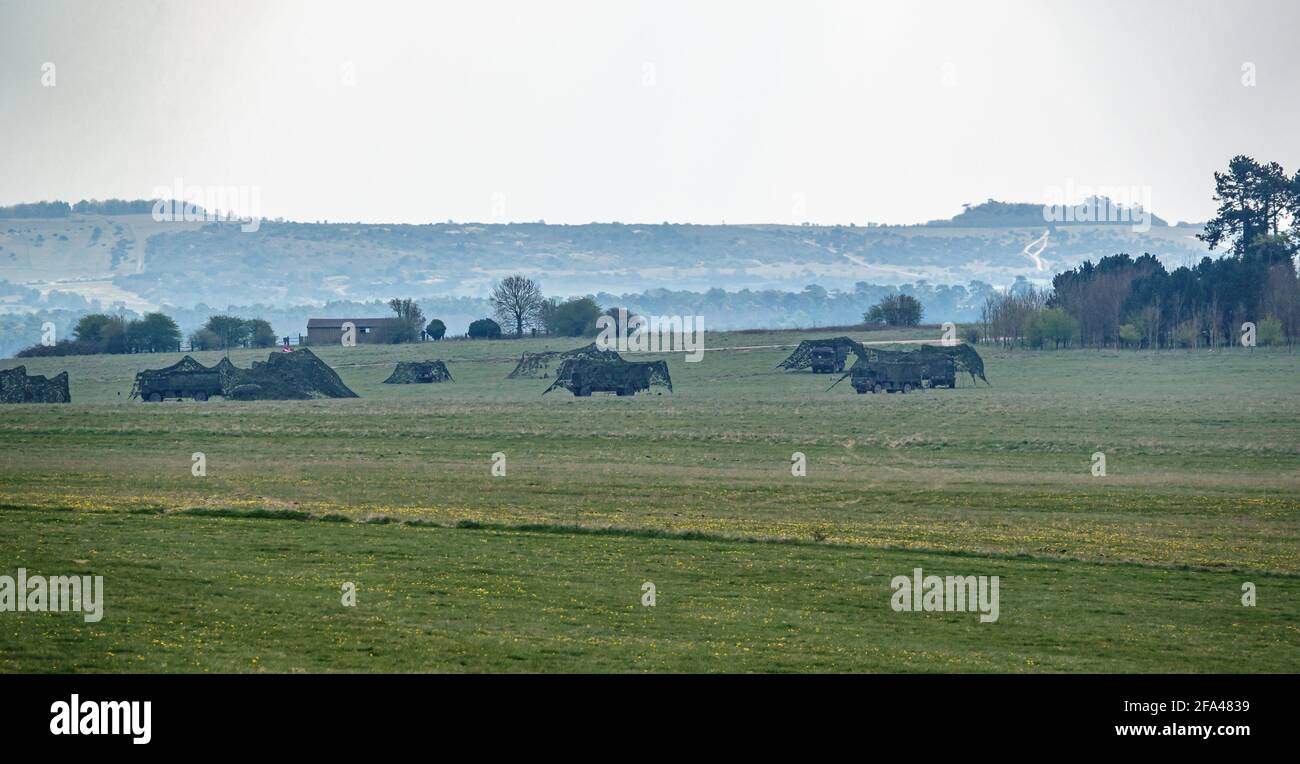 british army on exercise with equipment and machinery under camouflage ...