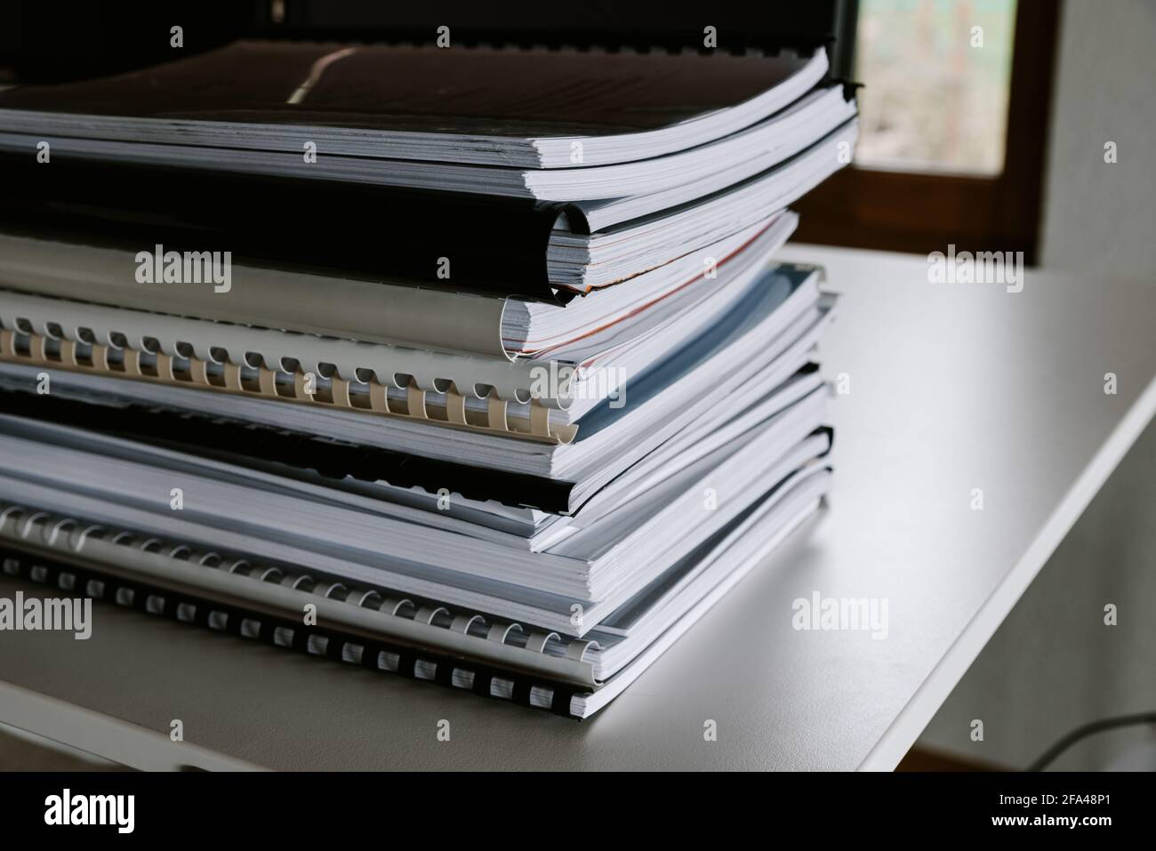 Stack of reports lies on a desk ready for review Stock Photo - Alamy