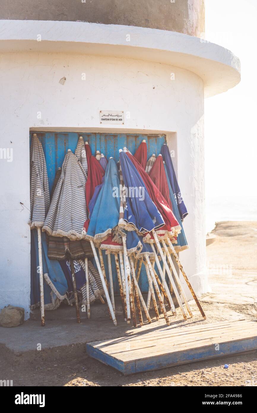 Parasols stand folded against a wall Stock Photo - Alamy