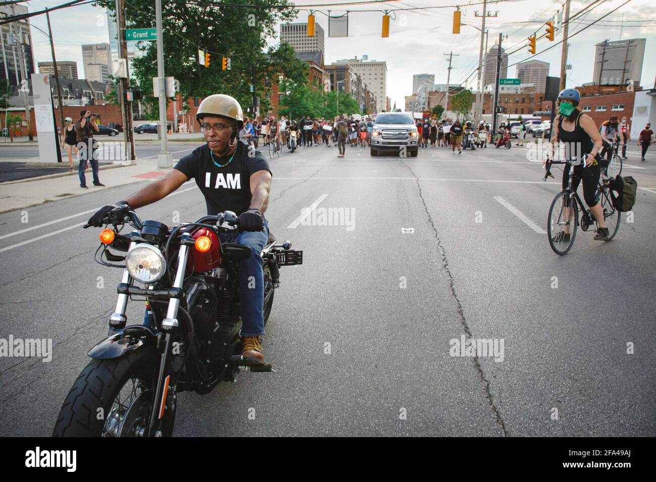 A man on a motorcycle leads a protest March through a city street Stock ...