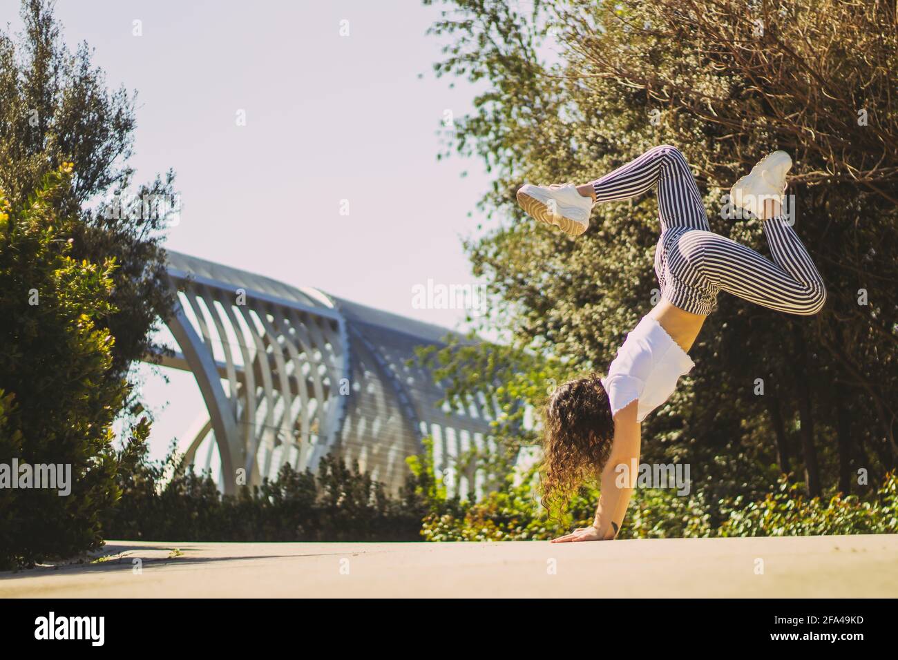 woman doing a handstand in the street against a bridge Stock Photo - Alamy