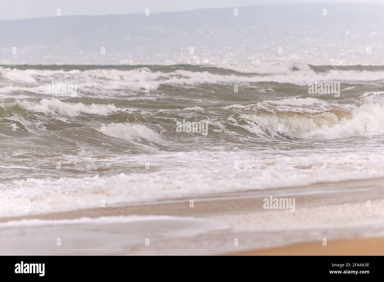 Storm at sea. High waves lift tons of sand from the bottom. Whitecaps ...
