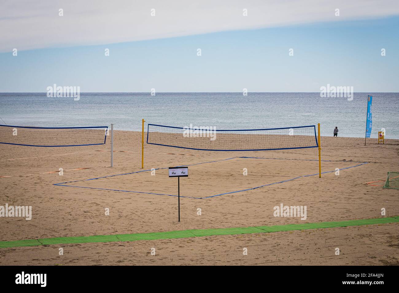 Beach volleyball court with blue sea and sky in the background. Empty ...