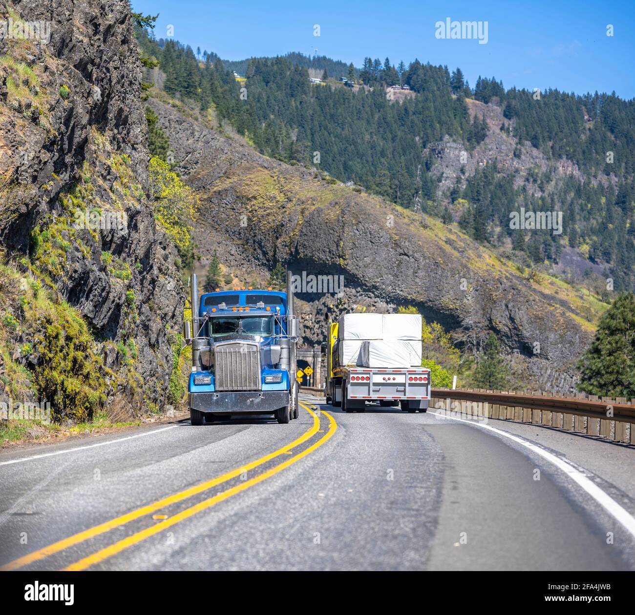 Different classic loaded big rigs semi trucks with semi trailers moving ...