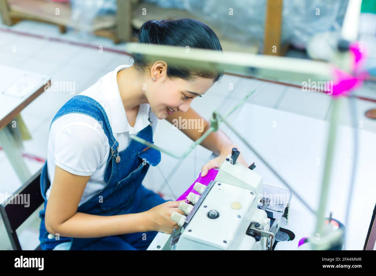 Asian Seamstress or worker in a Indonesian factory sewing with a ...