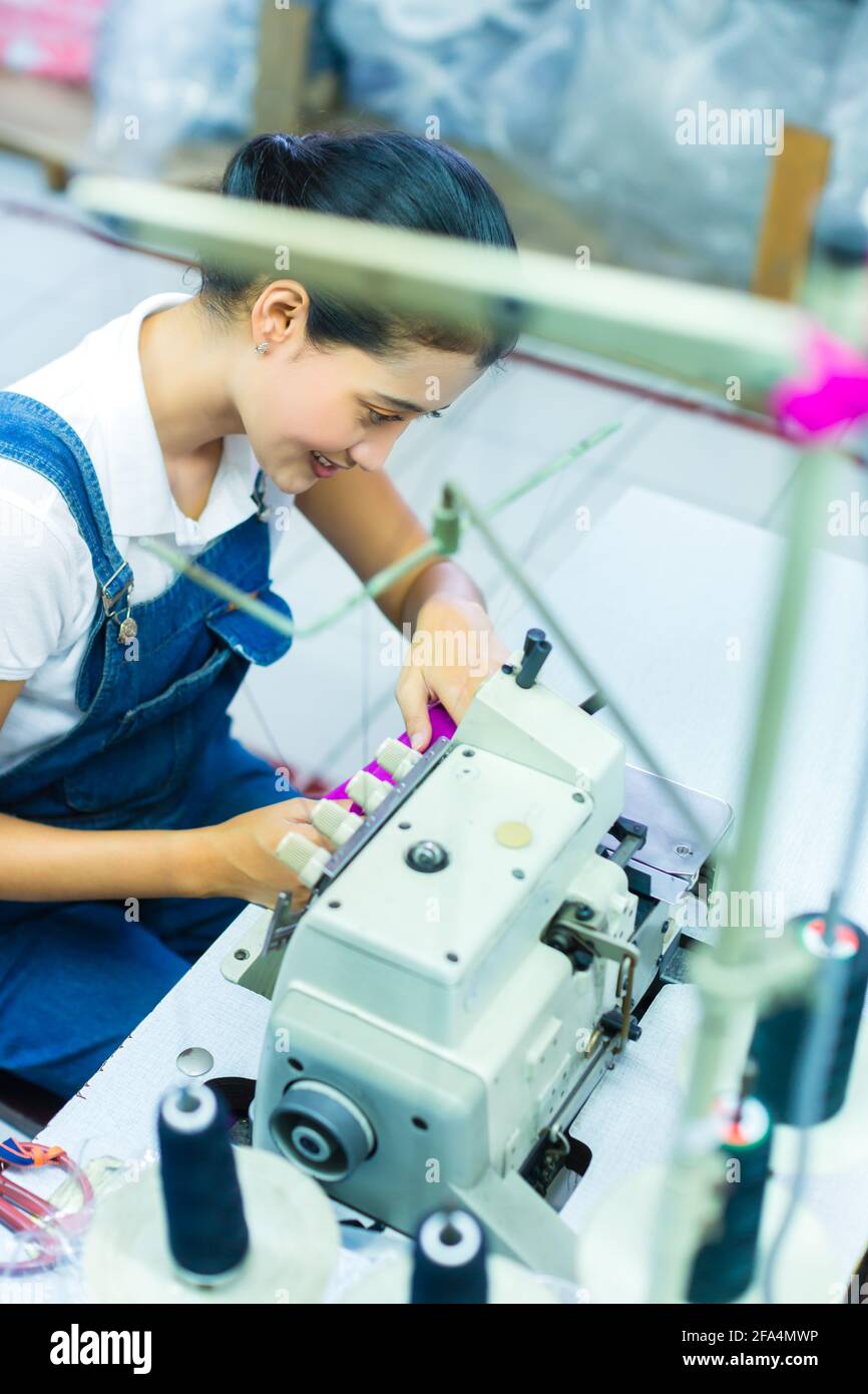 Asian Seamstress or worker in a Indonesian factory sewing with a ...