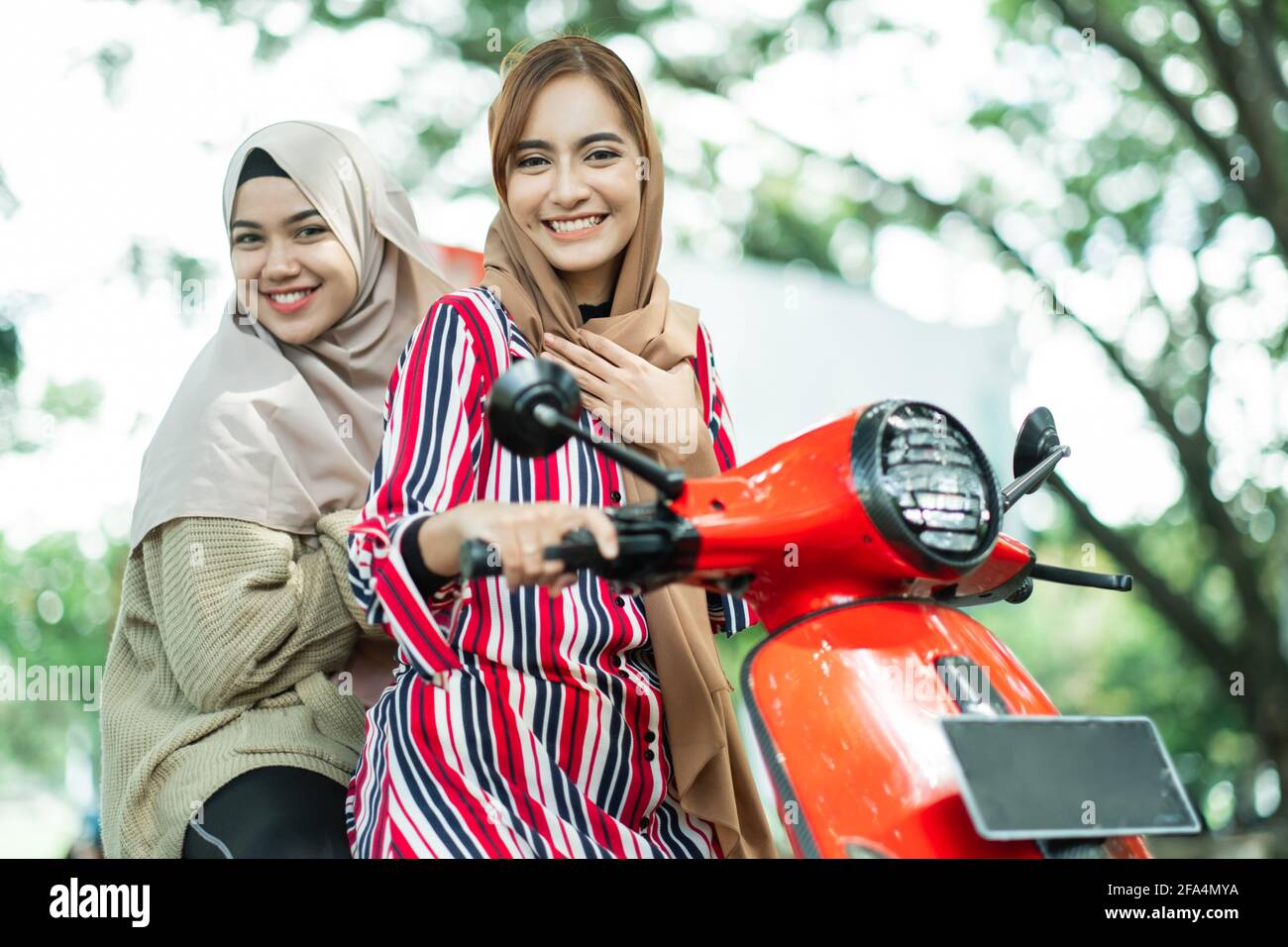 happy muslim friend riding motorcycle scooter together Stock Photo - Alamy