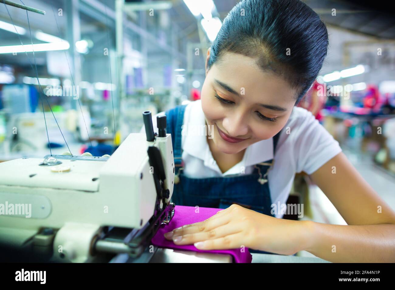 Asian Seamstress or worker in a Indonesian factory sewing with a ...