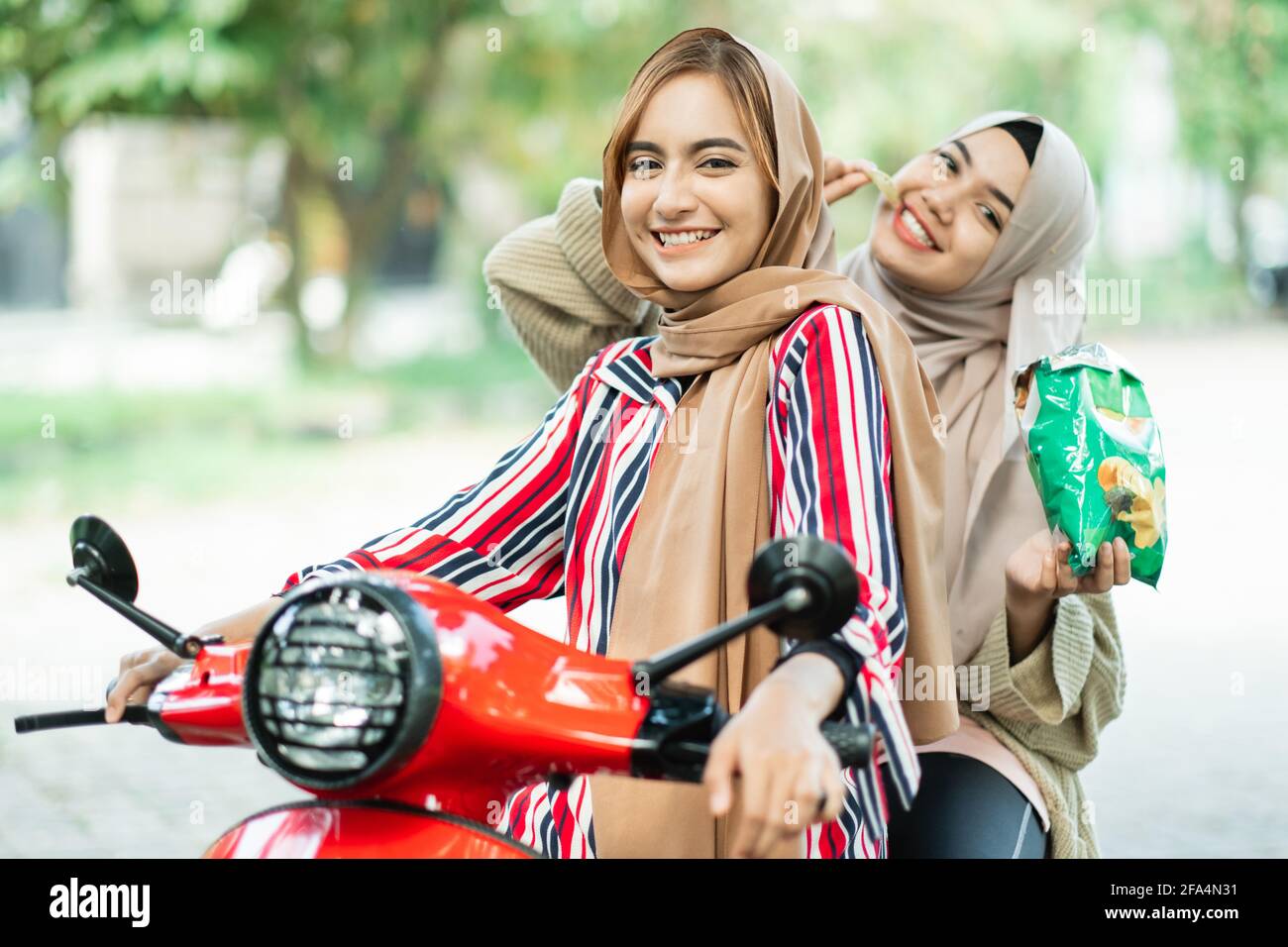 happy muslim friend riding motorcycle scooter together Stock Photo - Alamy