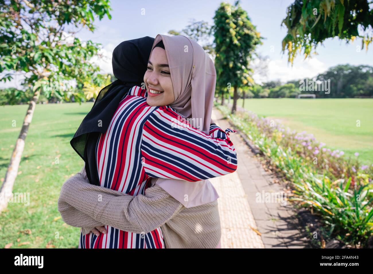 Two girls hug on the sidewalk. Feel joyfull and happy together Stock ...