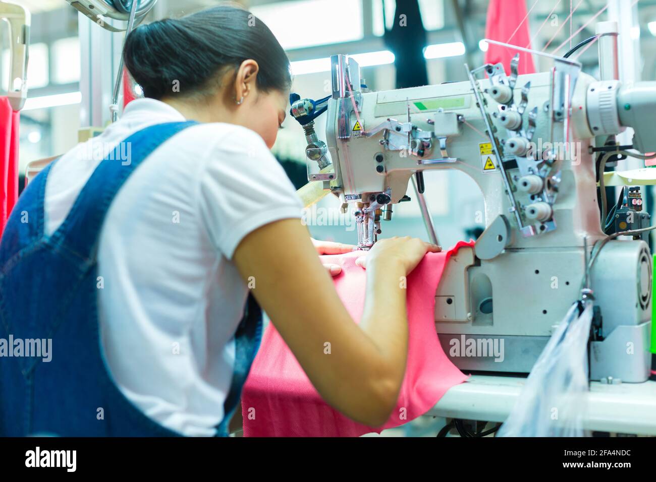 Asian Seamstress or worker in an Asian textile factory sewing with a ...