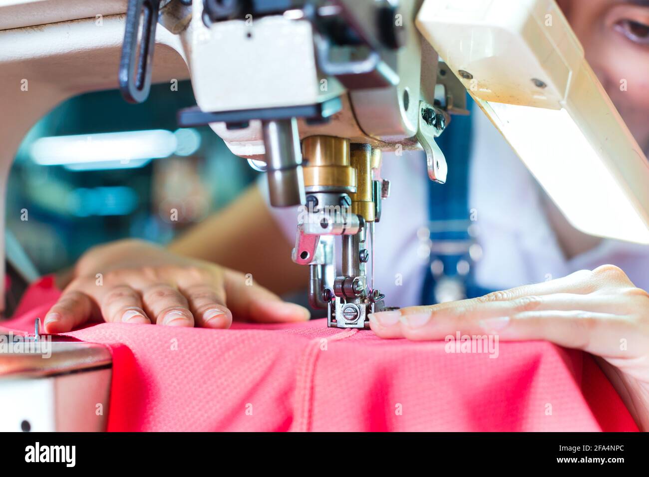 Asian Seamstress or worker in an Asian textile factory sewing with a ...