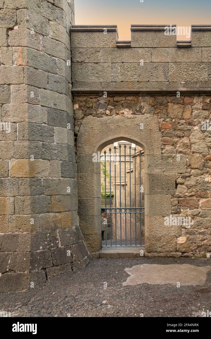 Ancient stone wall with a gate in the old castle. Wooden gate of a ...