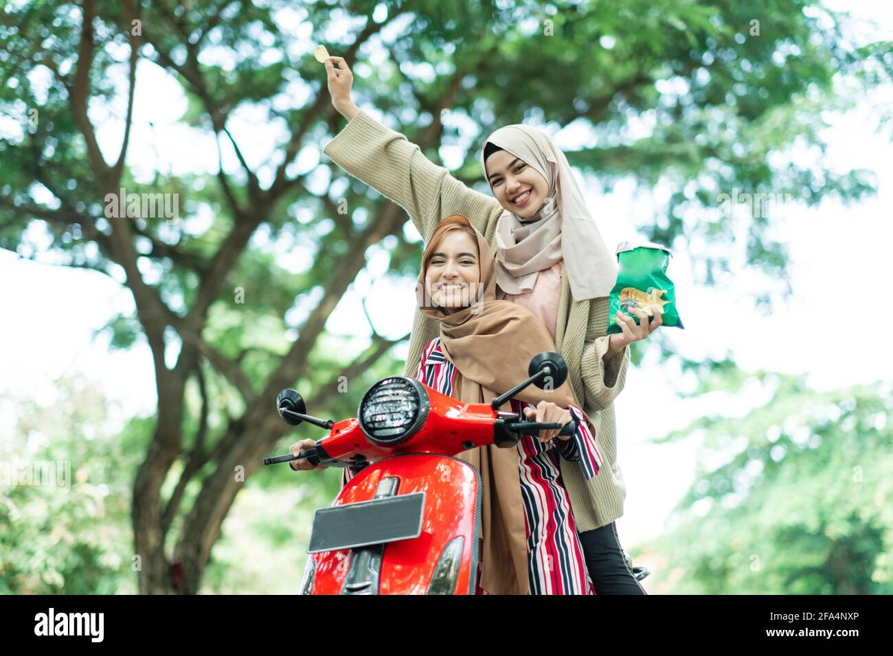 happy muslim friend riding motorcycle scooter together Stock Photo - Alamy