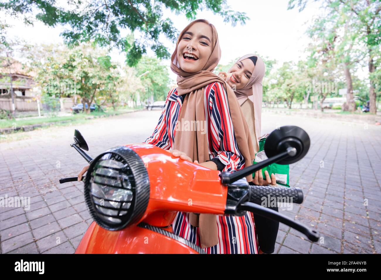happy muslim friend riding motorcycle scooter together Stock Photo - Alamy