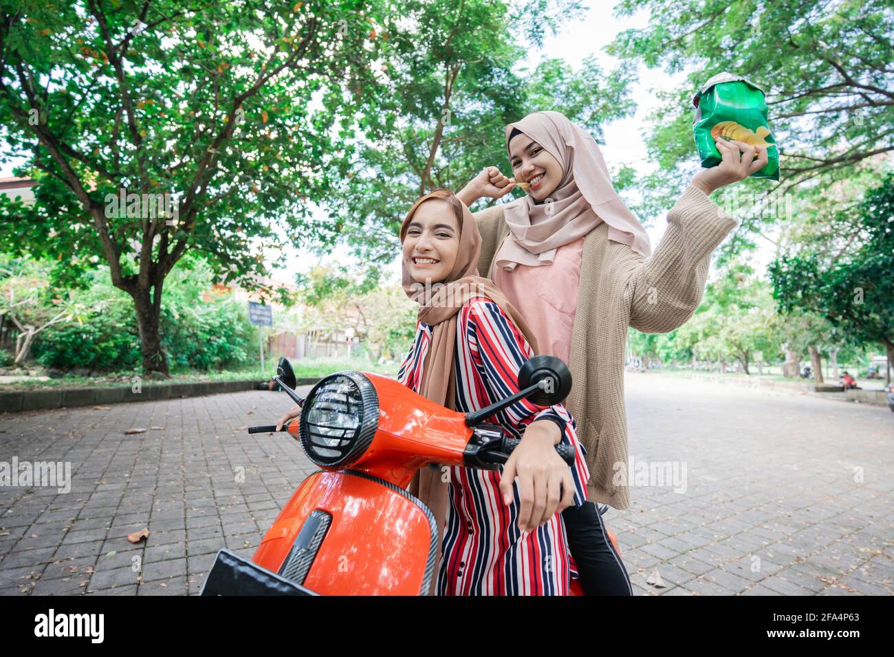 happy muslim friend riding motorcycle scooter together Stock Photo - Alamy