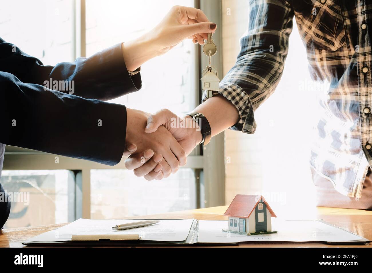Real estate agent and customers shaking hands together celebrating ...