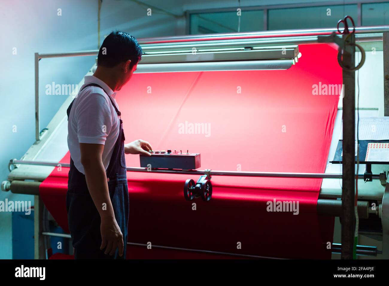 Indonesian textile worker in a manufacturing plant controls the quality ...