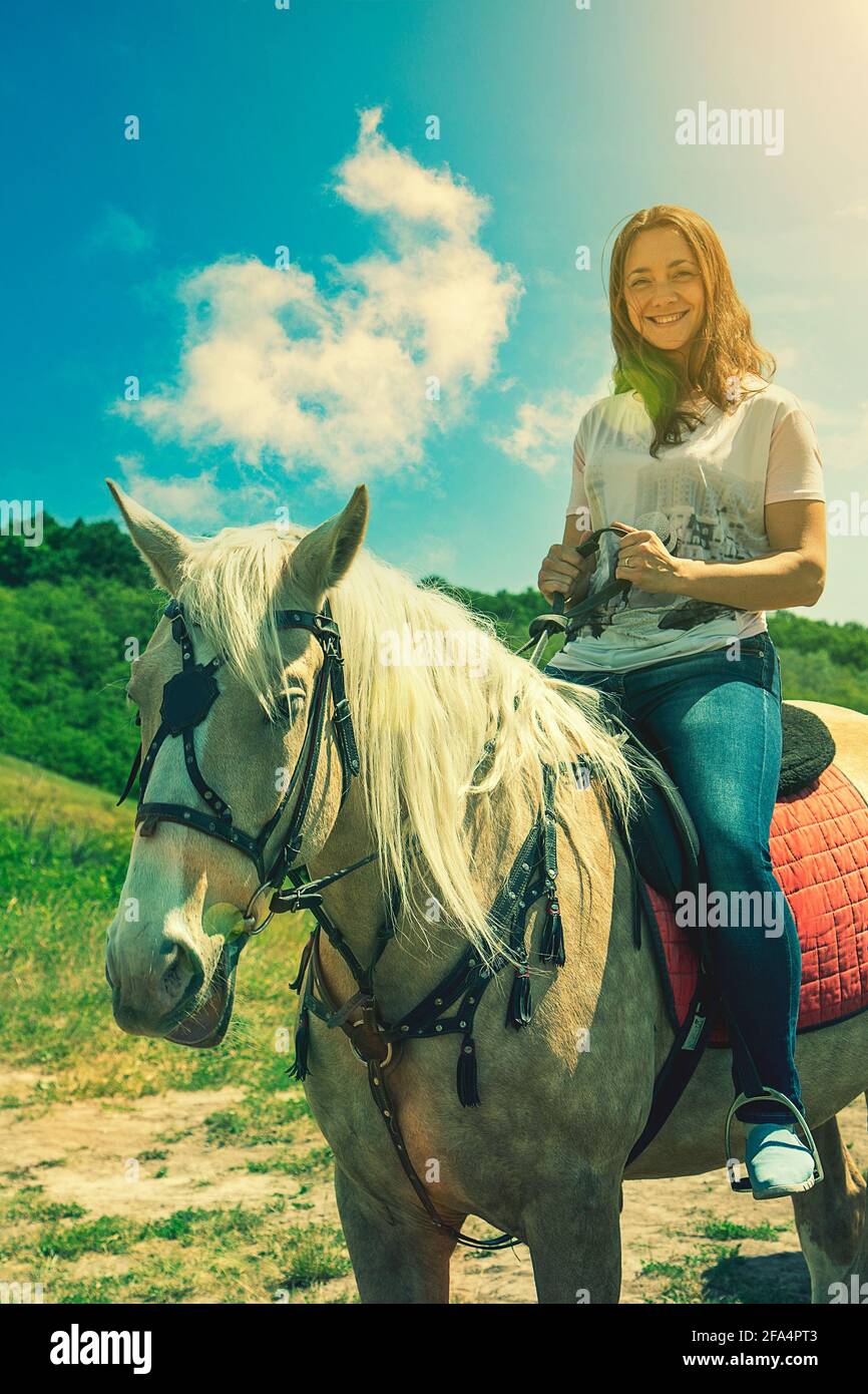 the rider on the white horse. Young horsewoman riding on white horse ...