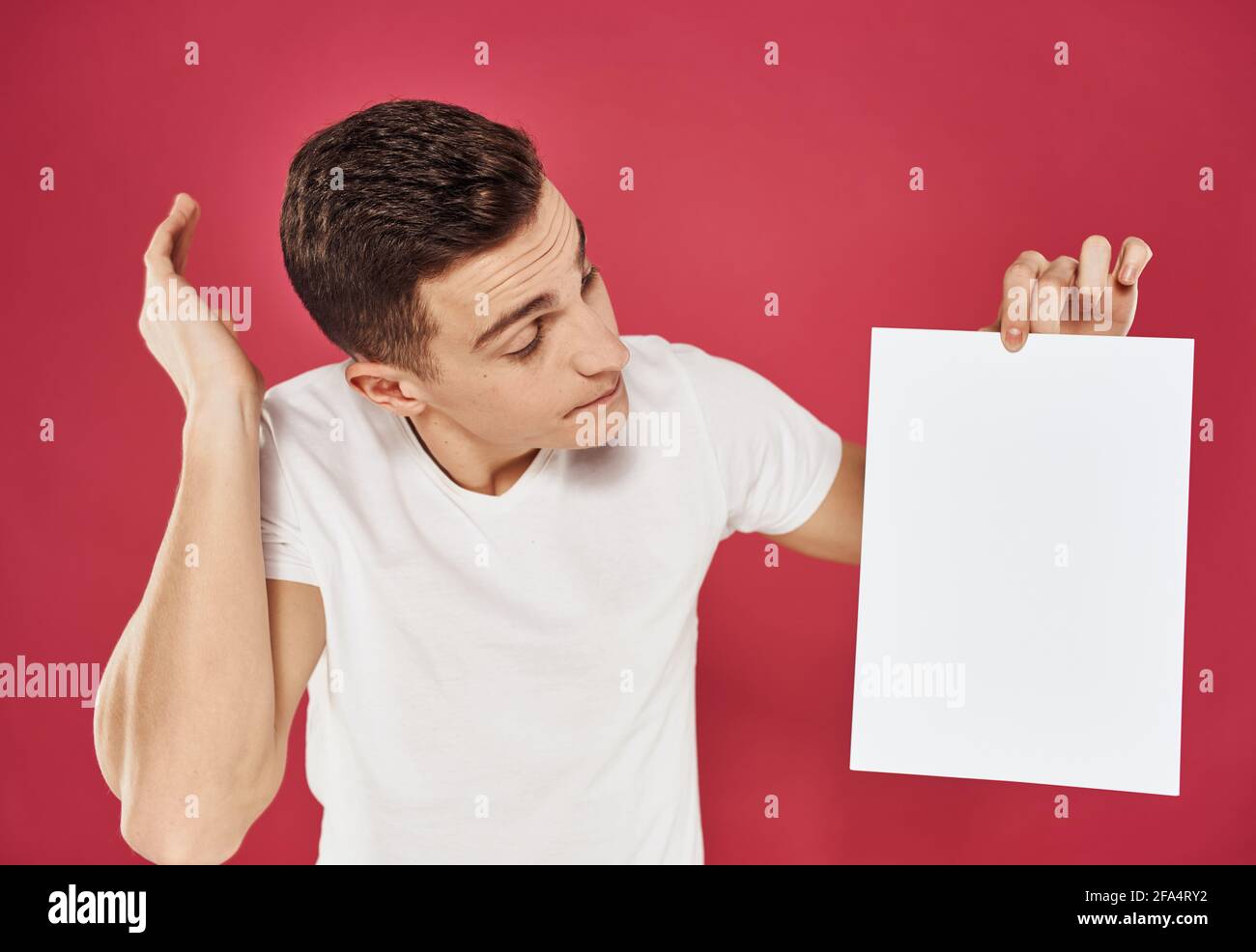 Man with a flyer in his hand on a red background advertising mockup ...
