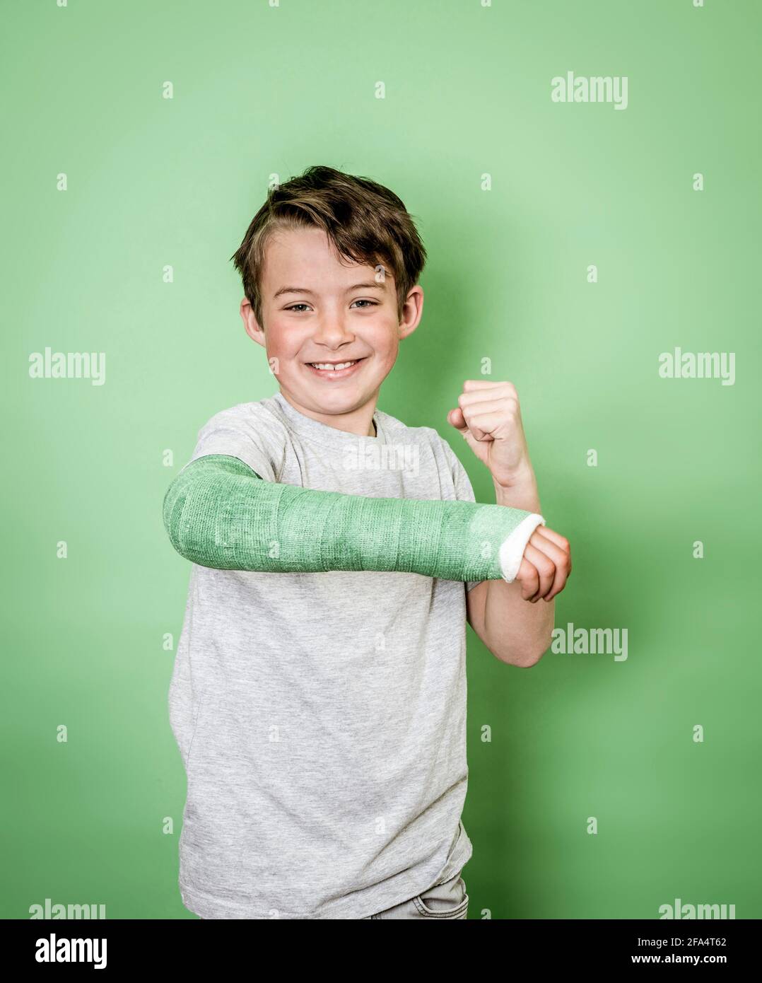 cool young schoolboy with broken arm and green arm plaster posing in ...