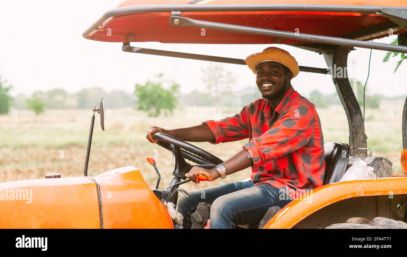 African man farmer working in the field with a tractor Stock Photo - Alamy
