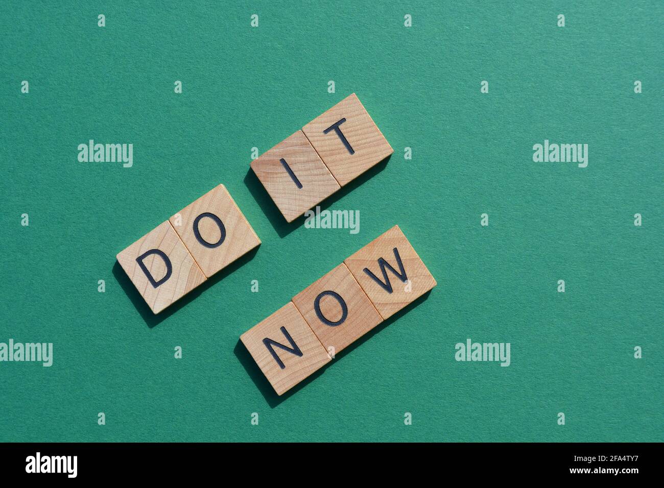 Do It Now, words in wooden alphabet letters isolated on green ...
