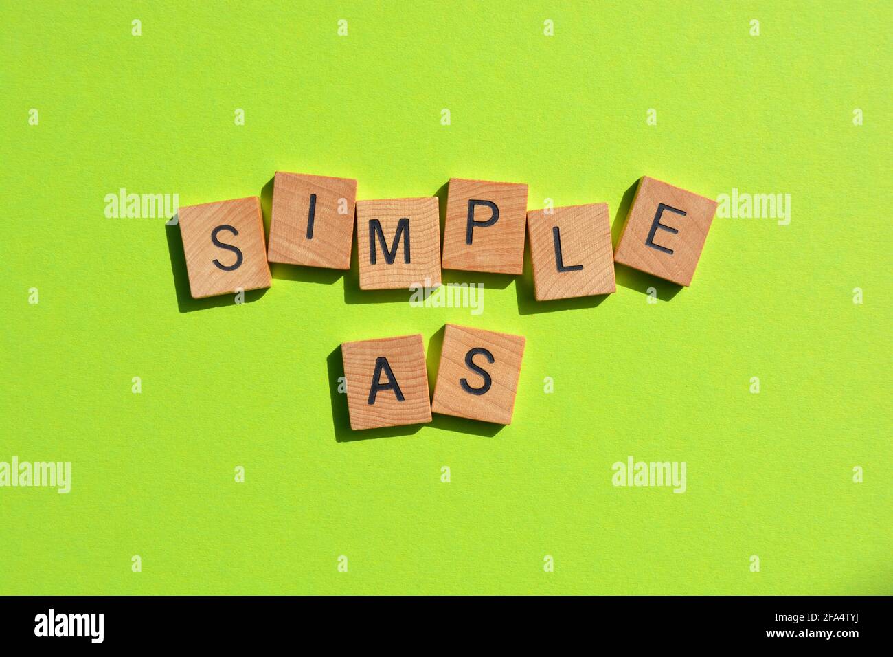 Simple As, words in wooden alphabet letters isolated on bright green ...