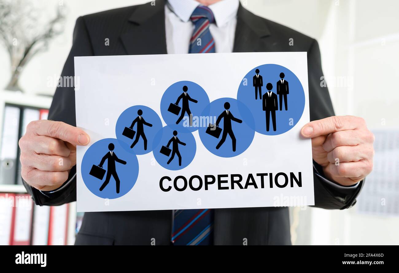 Paper showing cooperation concept held by a businessman Stock Photo - Alamy