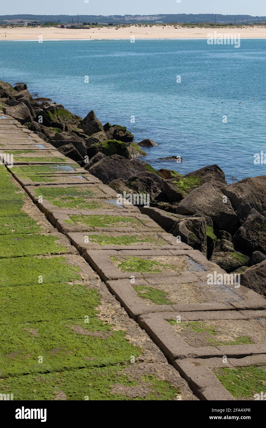 Vertical shot of breakwall and immense rock formations on coastline ...